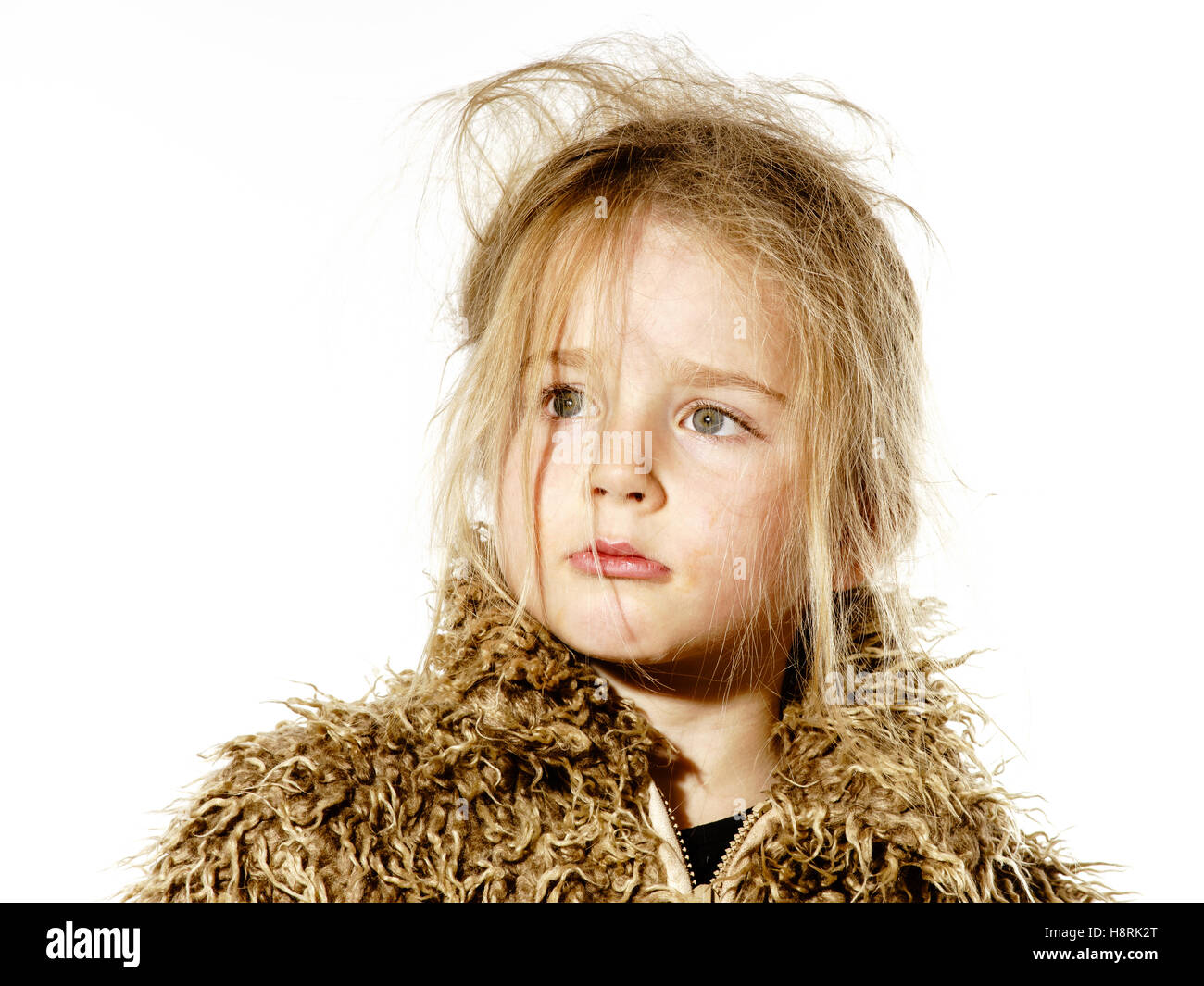 Disheveled preschooler girl with long hair dressed in fur coat ...