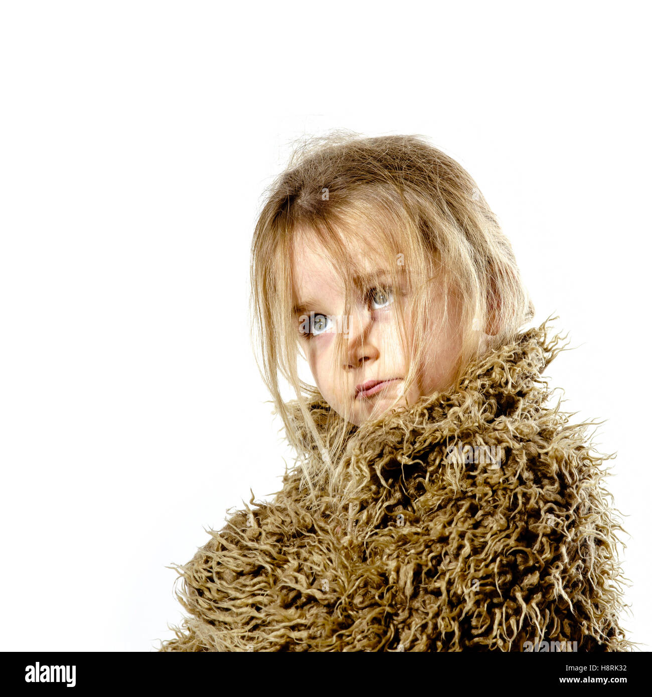 Disheveled preschooler girl with long hair dressed in fur coat ...