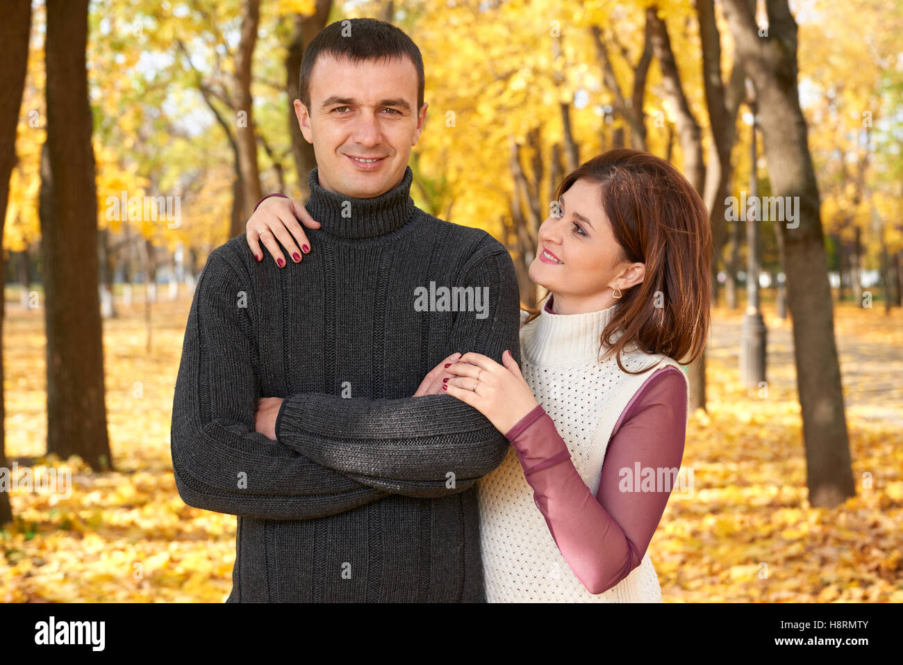 romantic people, happy adult couple embrace in autumn city park, trees ...