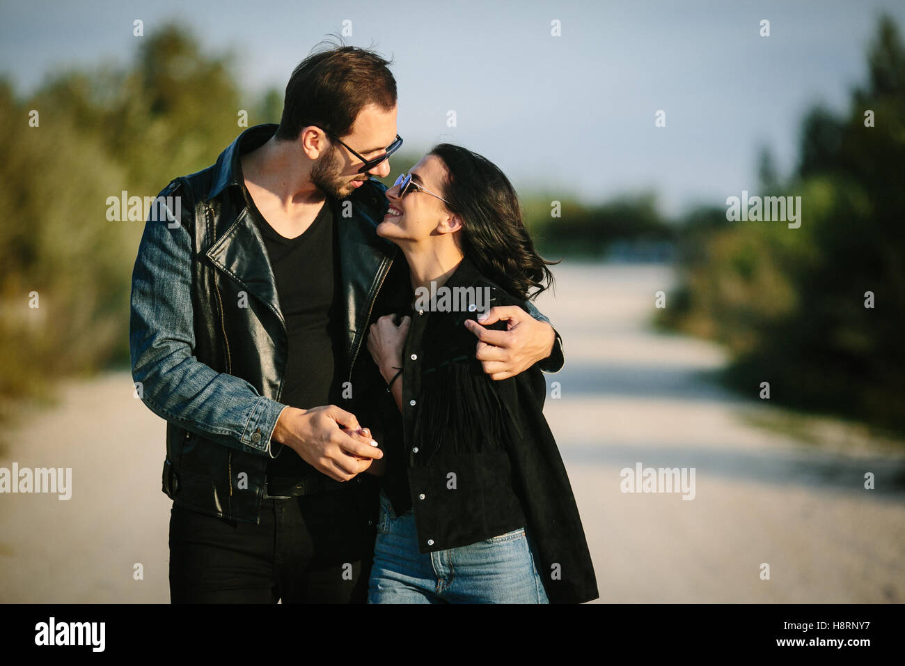 Young happy romantic couple walking along road Stock Photo - Alamy