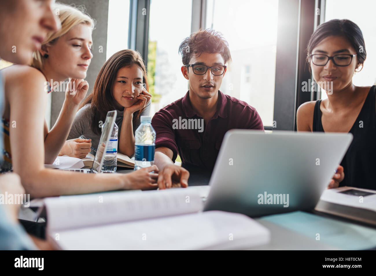 university friends socializing and studying together for exam in ...