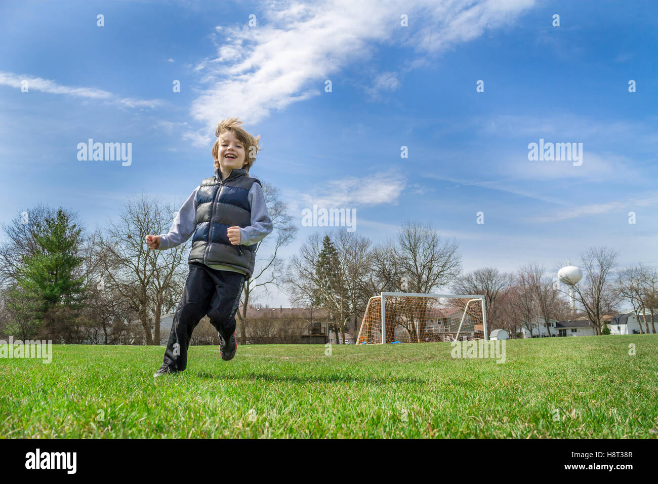 Little boy running on a soccer field Stock Photo - Alamy