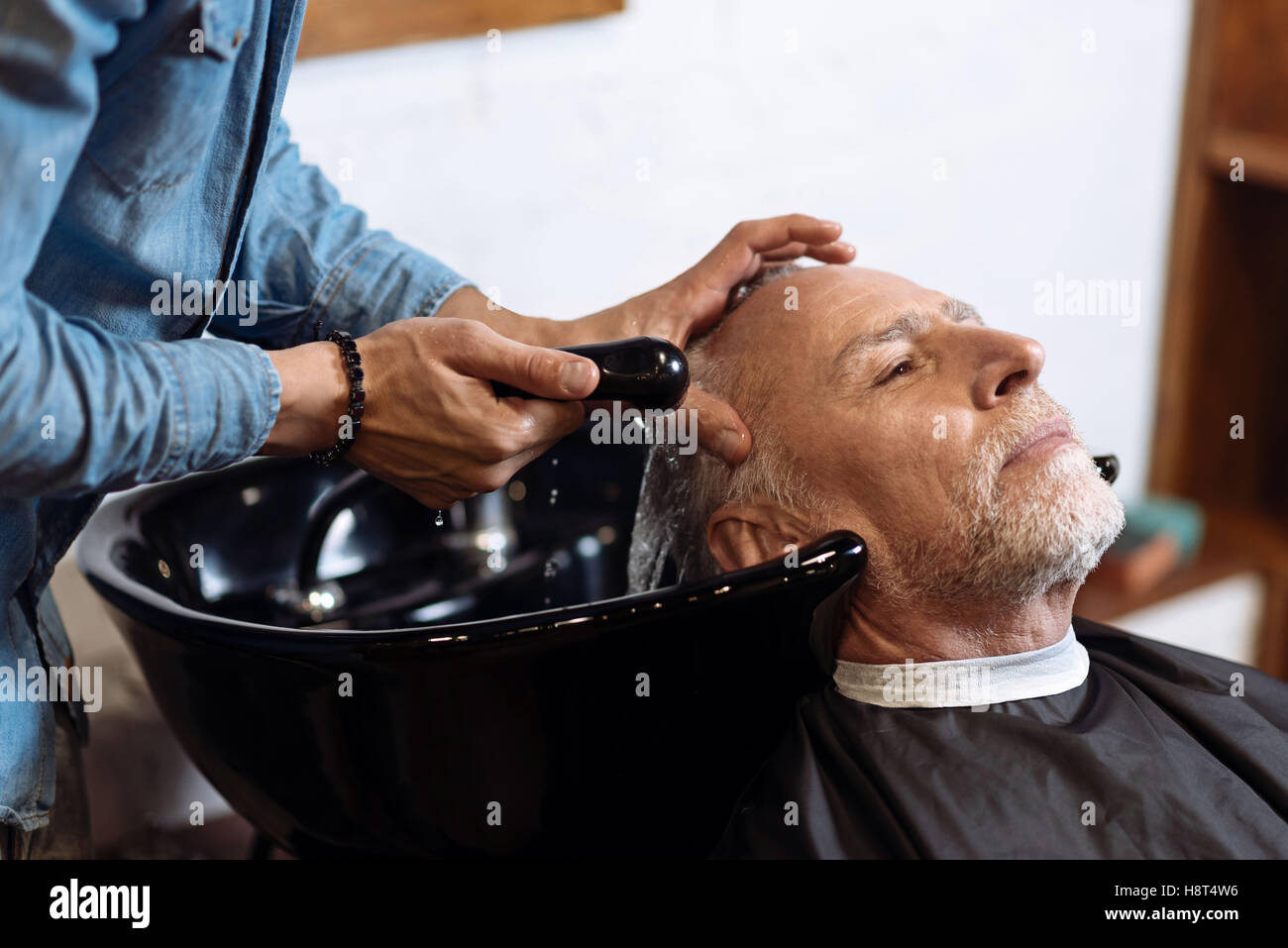 Old man during washing his hair in barber shop Stock Photo - Alamy