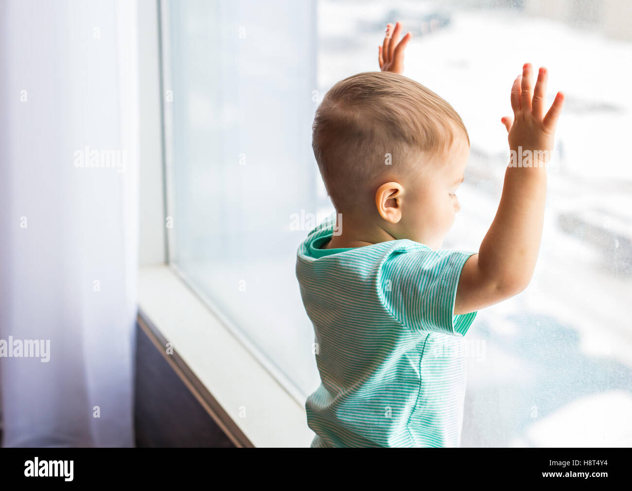 Smiling baby standing in room at home near window Stock Photo - Alamy