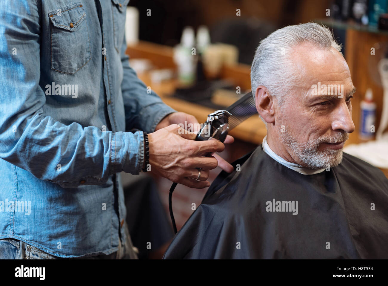 Close up barber trimming hair of old man Stock Photo - Alamy