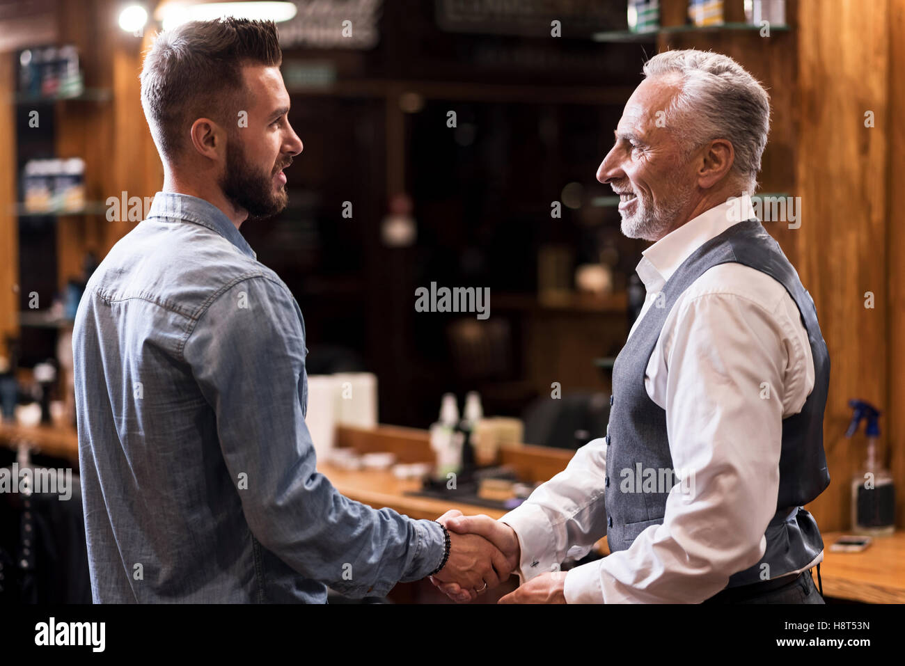 Barber and client shaking hands Stock Photo - Alamy