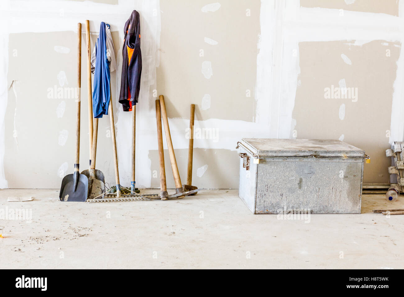 Set of different tools for earthworks are leaning against the wall ...