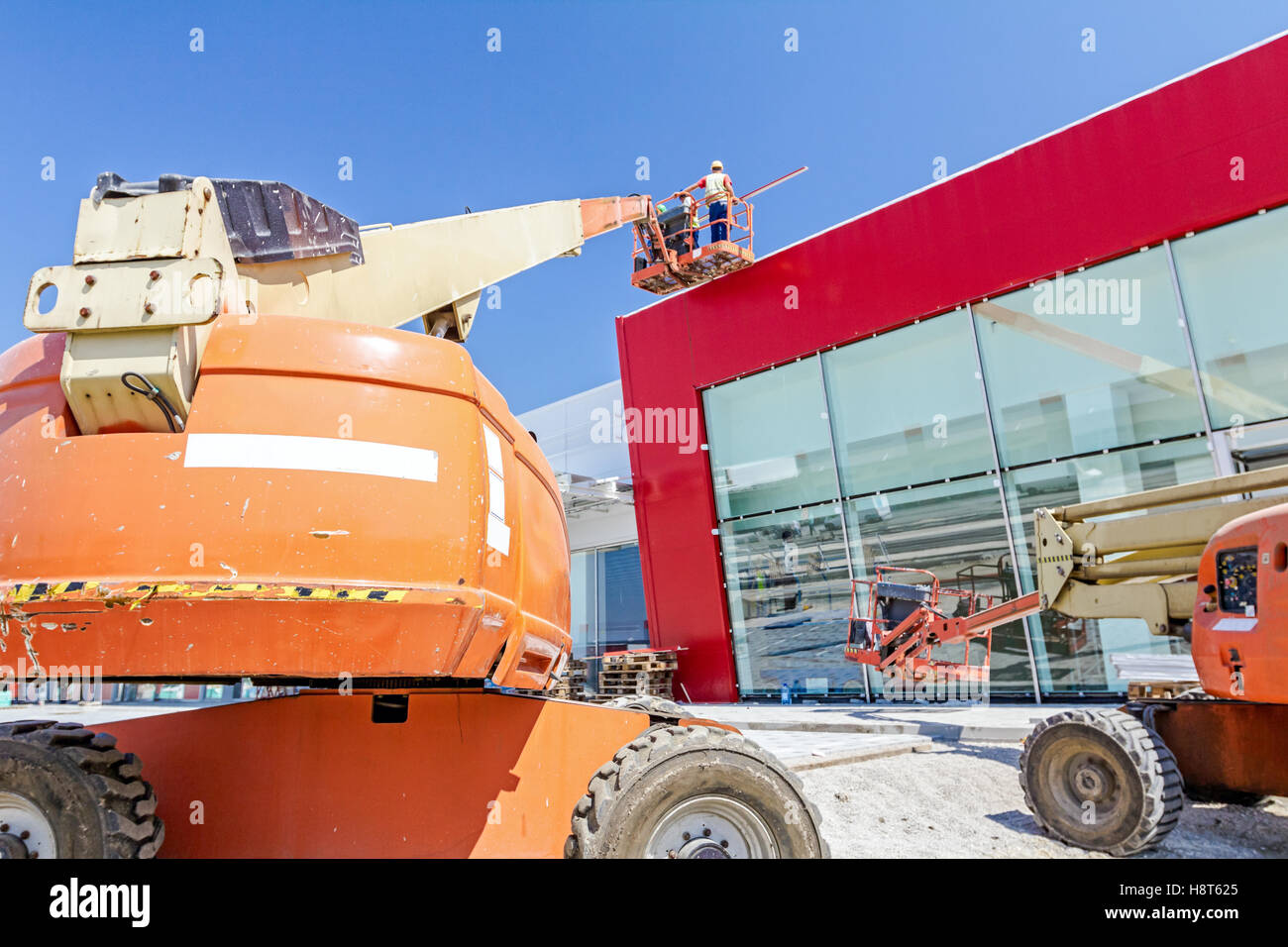 Cherry picker has elevated platform with riggers in safety basket at ...