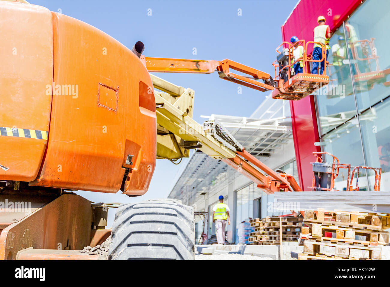 Cherry picker has elevated platform with riggers in safety basket at ...