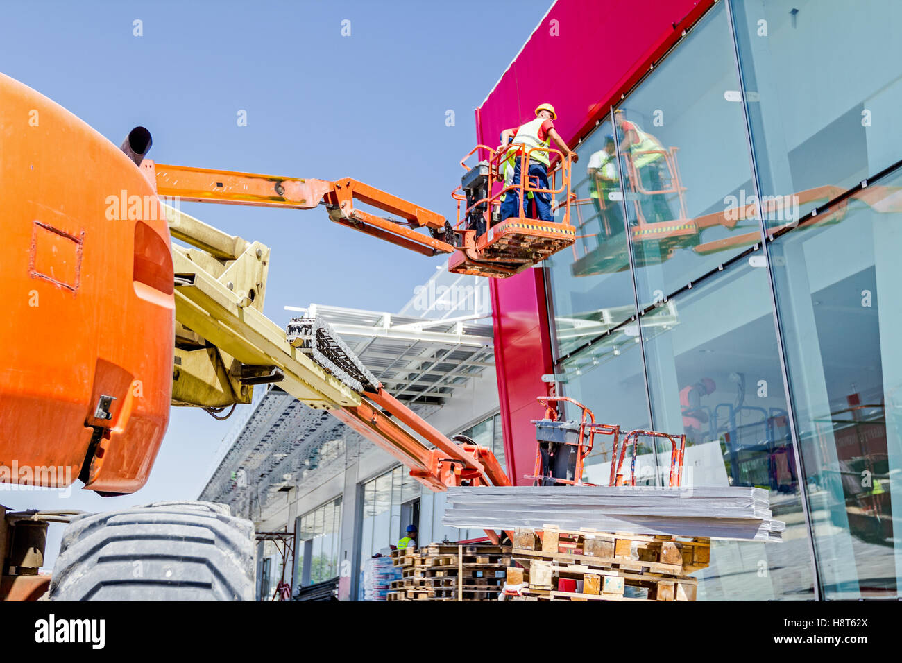 Cherry picker has elevated platform with riggers in safety basket at ...