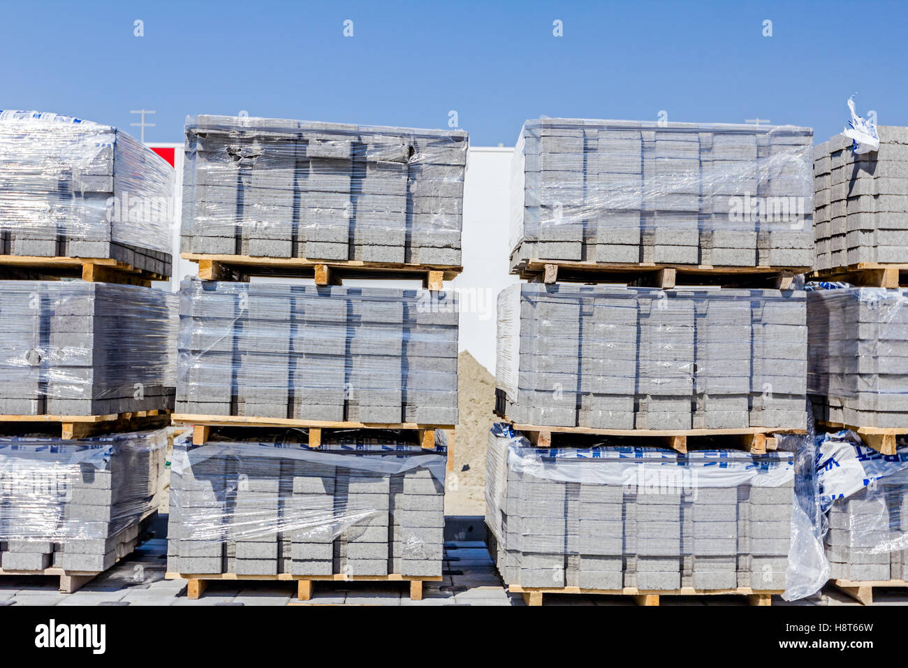 Wooden pallets with paving slabs are wrapped in plastic foil at ...