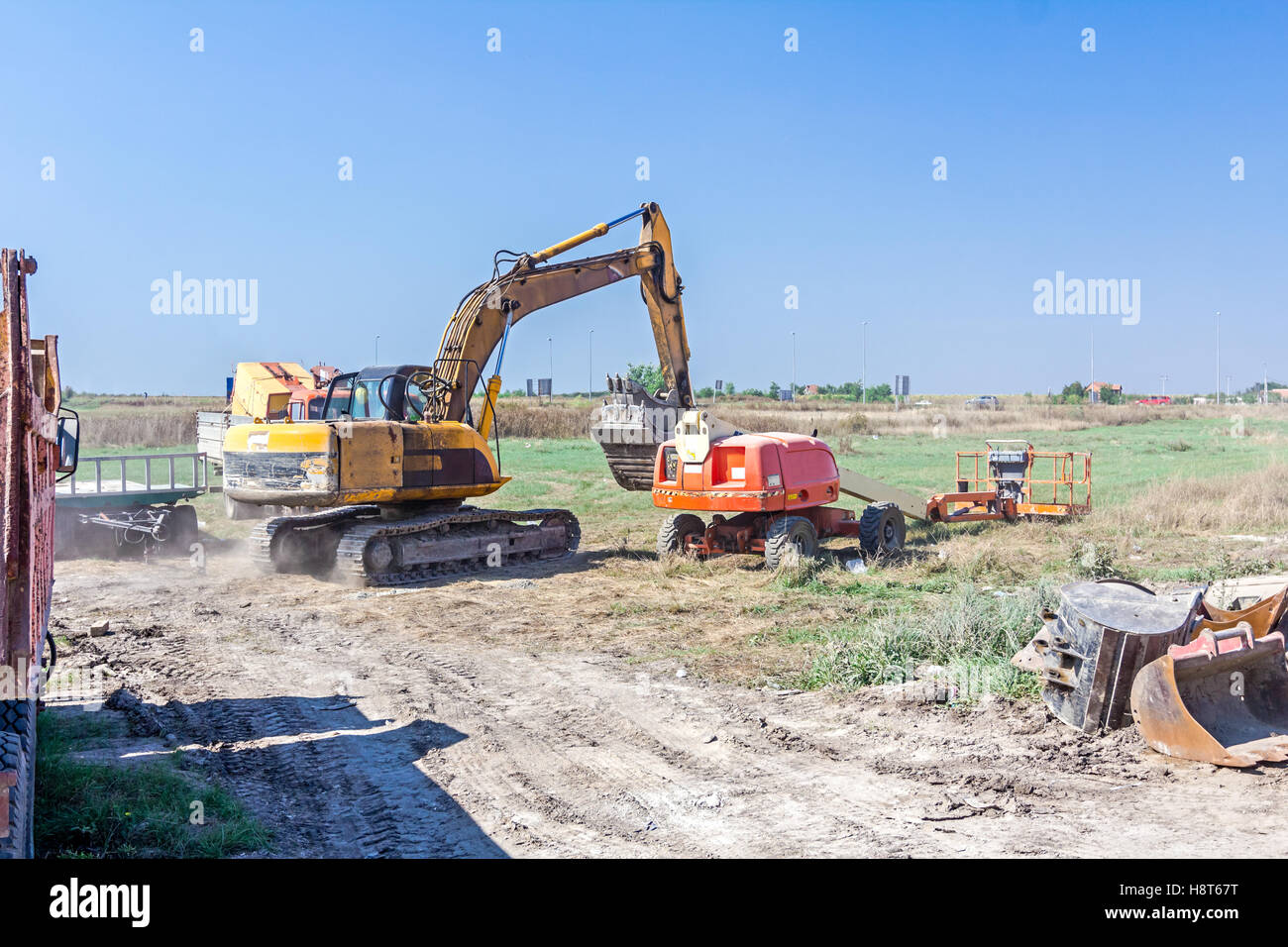 Excavator and cherry picker are parked near building site Stock Photo ...