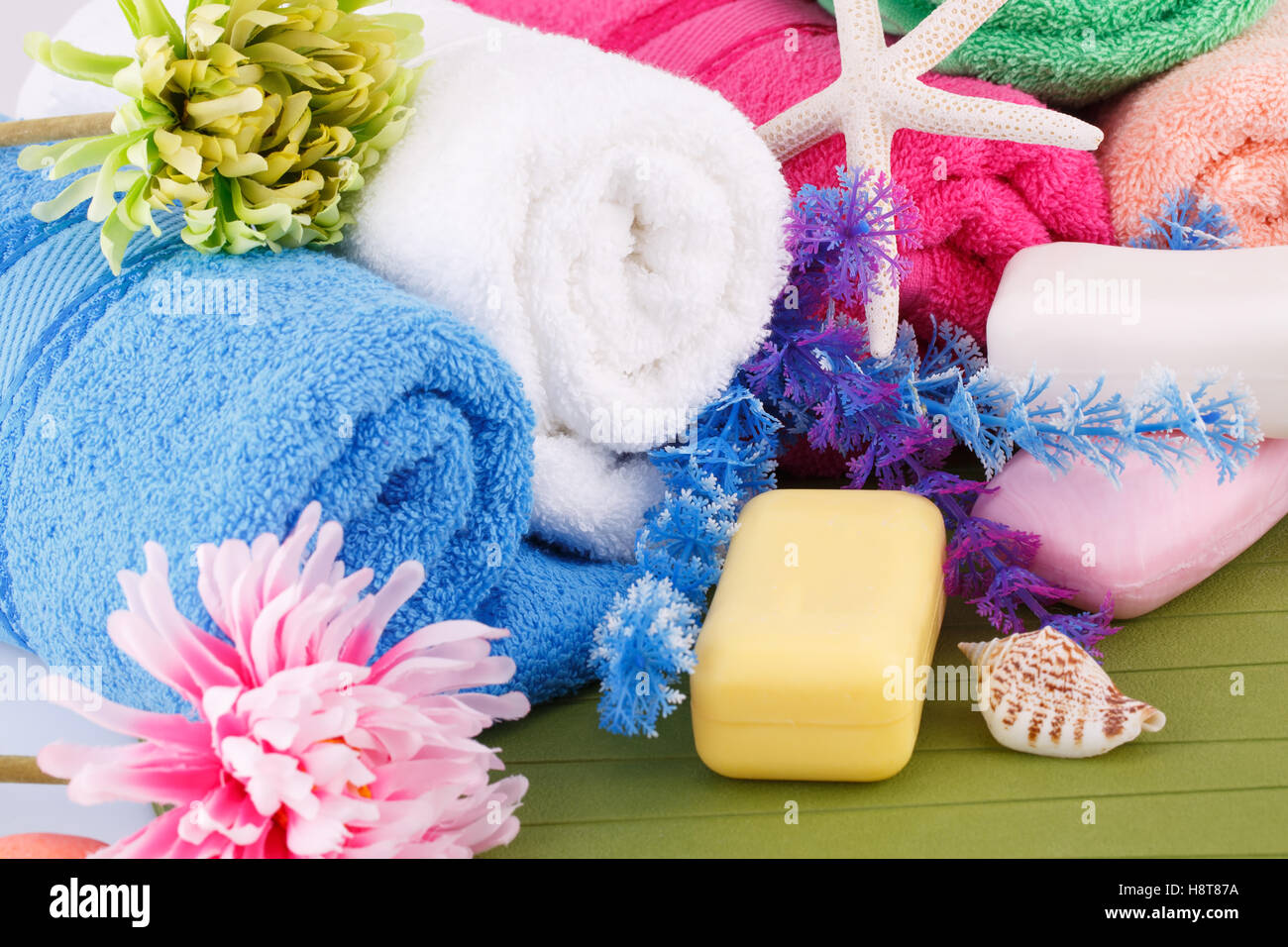 Colorful rolled towels with flowers and soaps closeup picture Stock ...