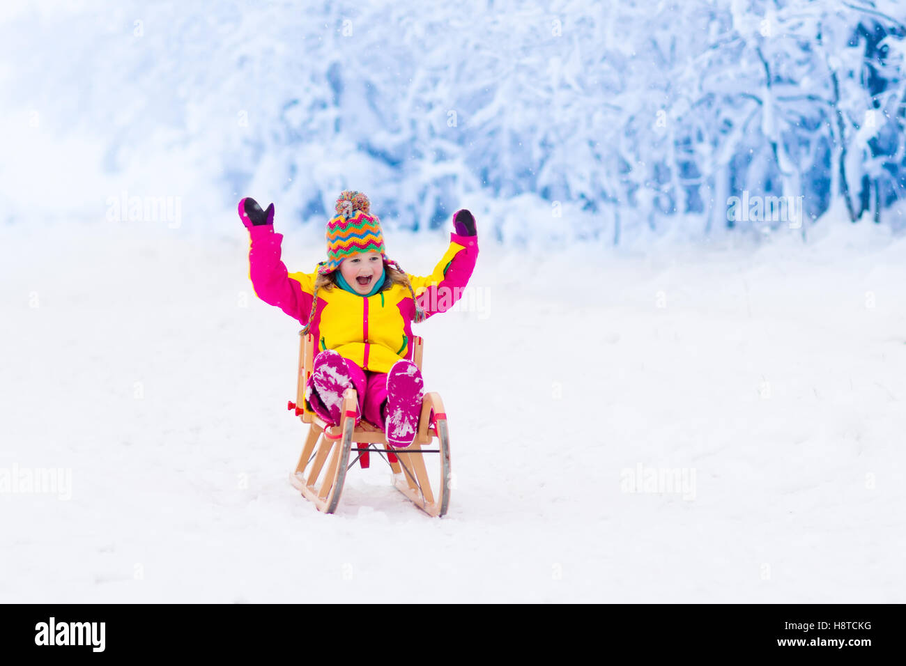 Little girl enjoying a sleigh ride. Child sledding. Toddler kid riding ...