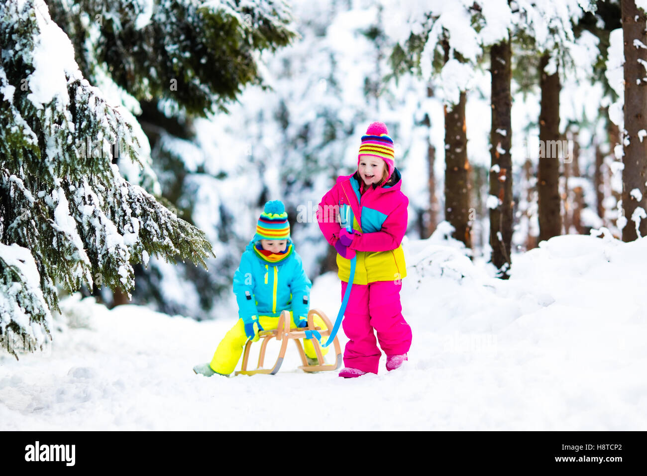 Little girl and boy enjoying sleigh ride. Child sledding. Toddler kid ...