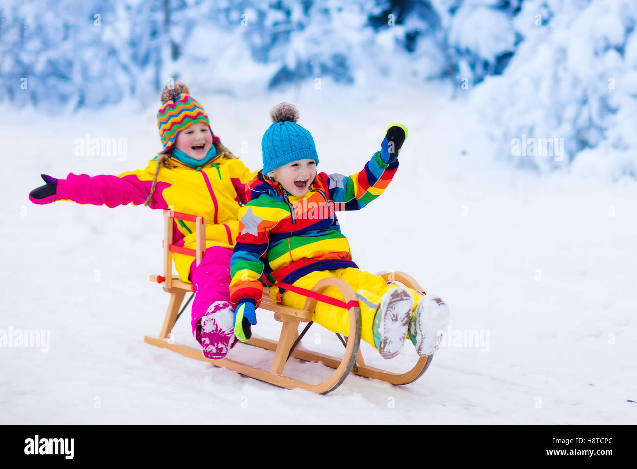 Little girl and boy enjoying sleigh ride. Child sledding. Toddler kid ...
