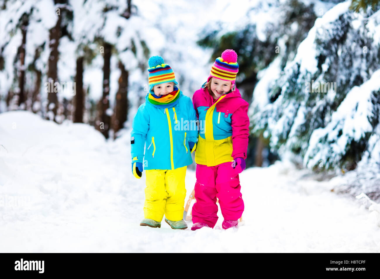 Little girl and boy enjoying sleigh ride. Child sledding. Toddler kid ...