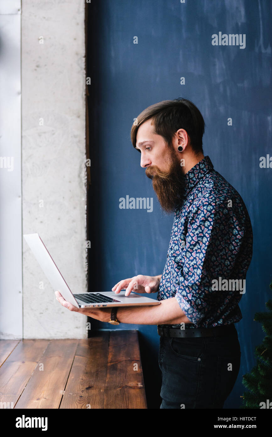 Bearded man working at his laptop Stock Photo - Alamy