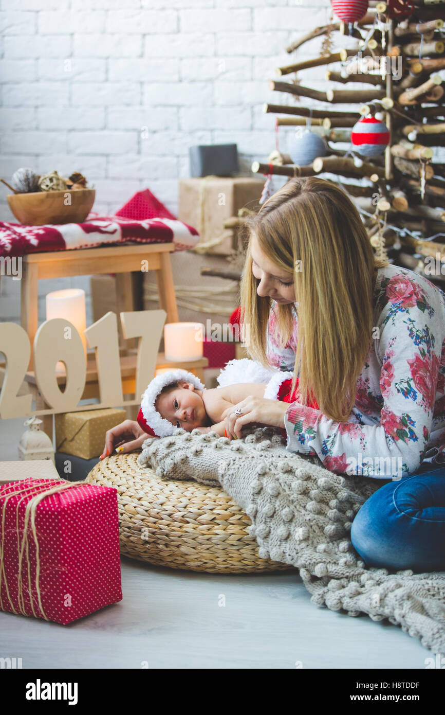 Young woman and her newborn baby in Santa clothes Stock Photo - Alamy