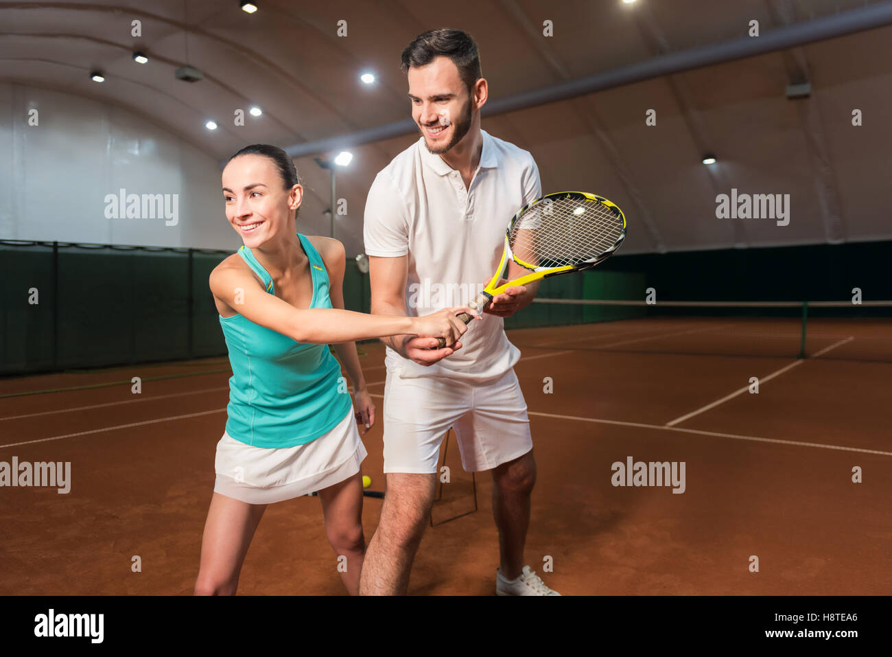 Cheerful professional instructor teaching to play tennis Stock Photo ...