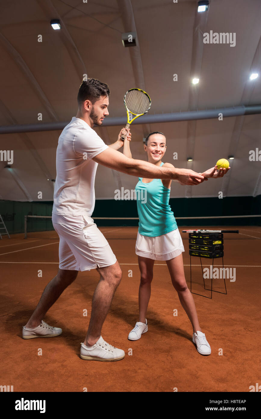 Professional tennis instructor teaching how to serve Stock Photo - Alamy