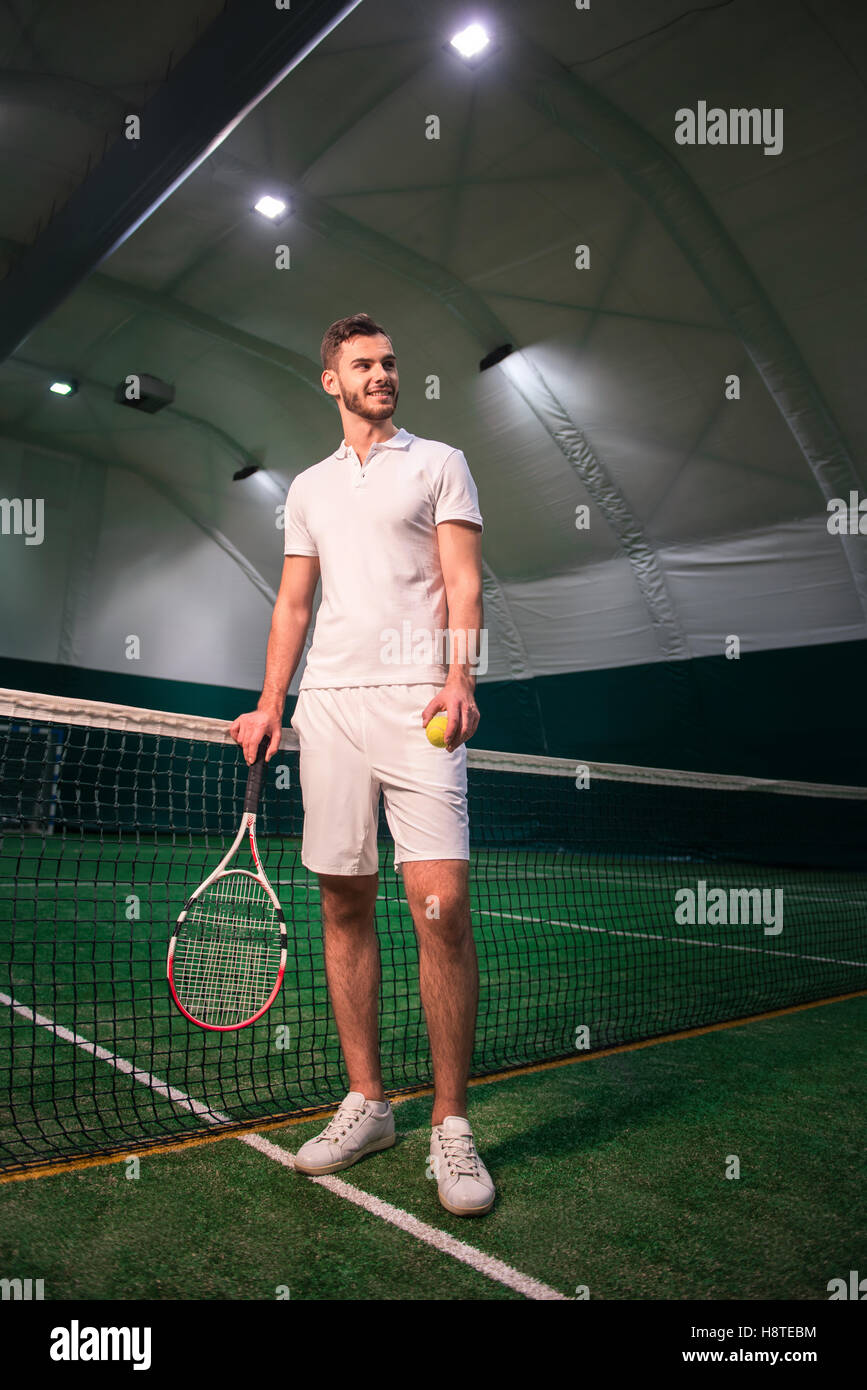 Delighted handsome tennis player going to play Stock Photo - Alamy