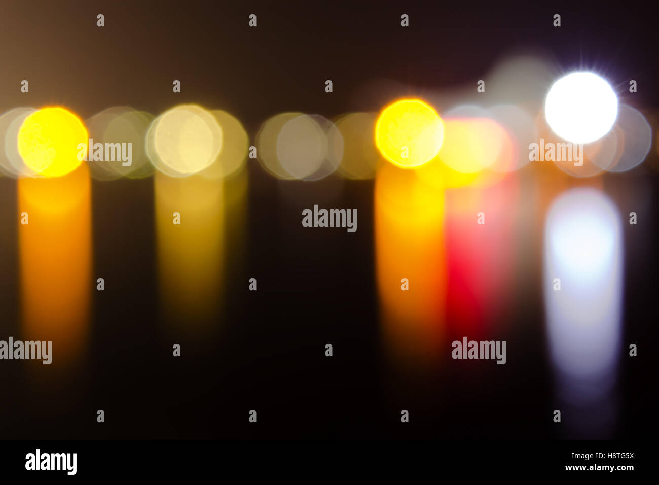 Blur/defocus shot of colorful lights on a pier and its reflections on ...