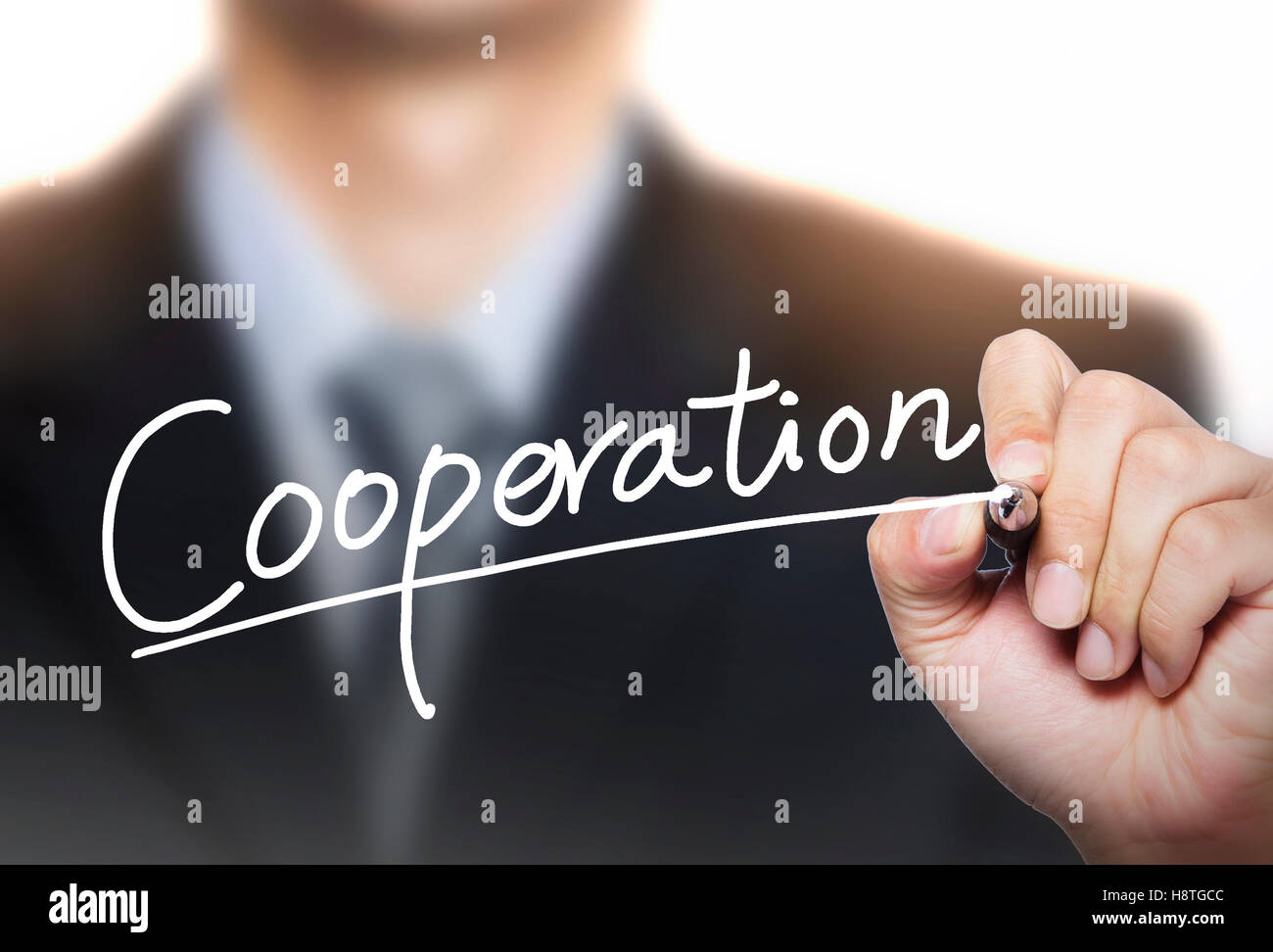 cooperation written by hand, hand writing on transparent board, photo ...