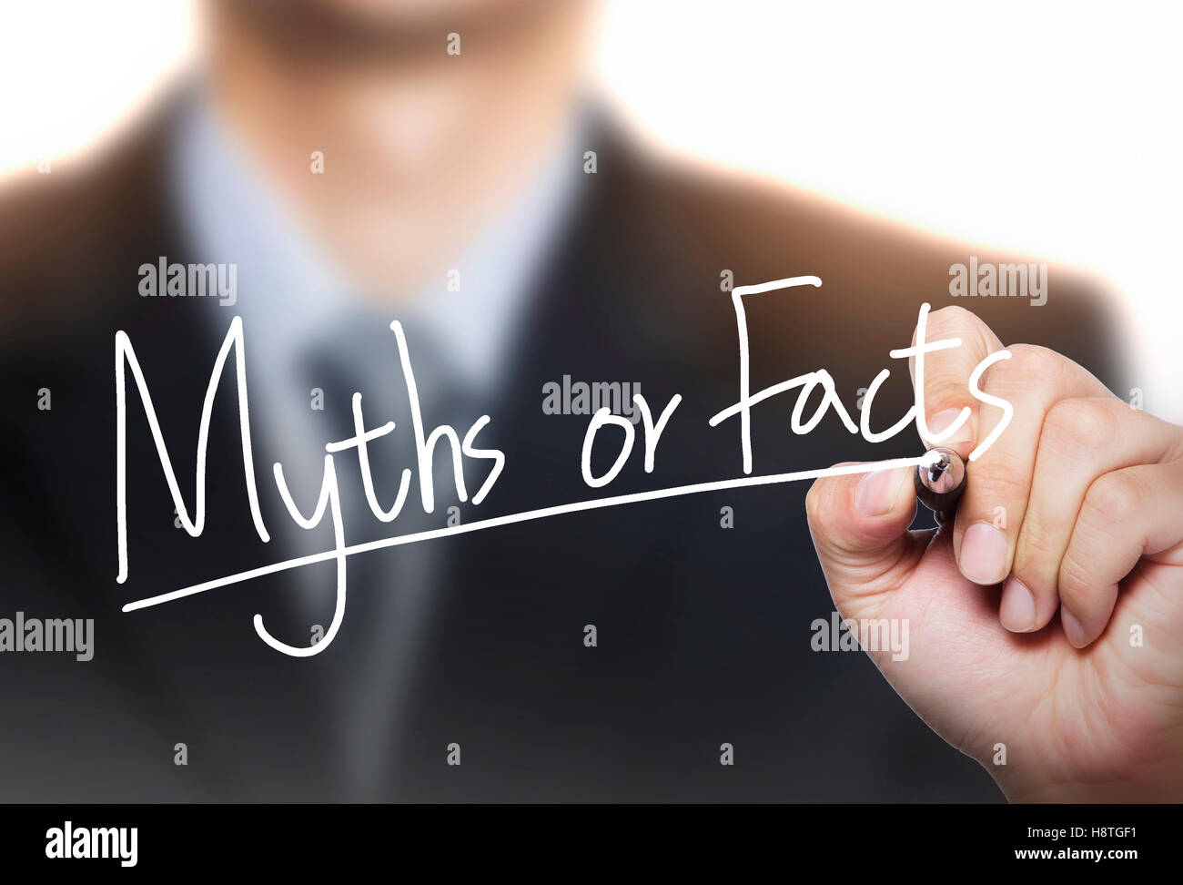 myths or facts written by hand, hand writing on transparent board ...