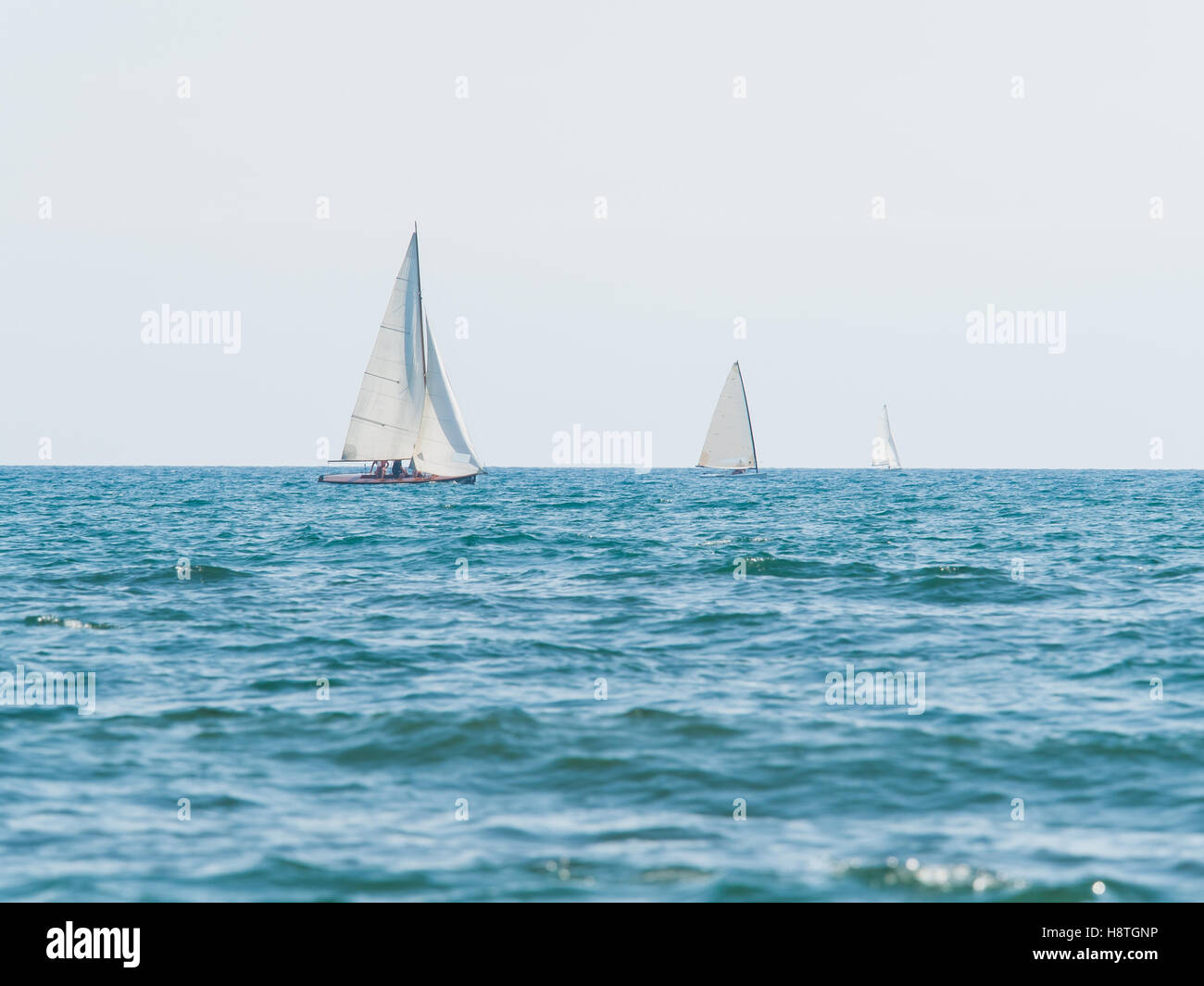 three small sailboats sailing parallel in a sunny day Stock Photo - Alamy