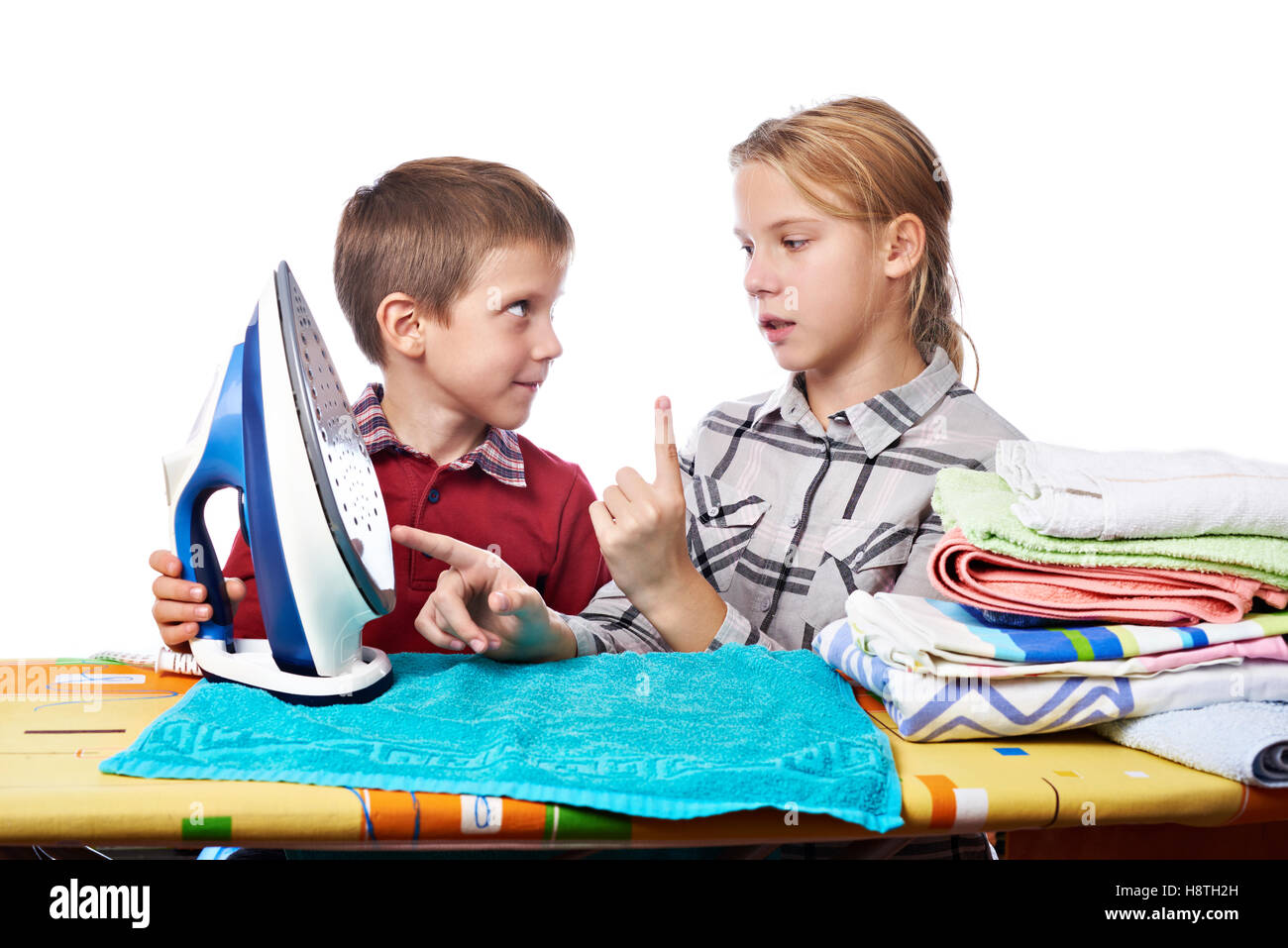 Sister helps younger brother to properly handle iron isolated white ...