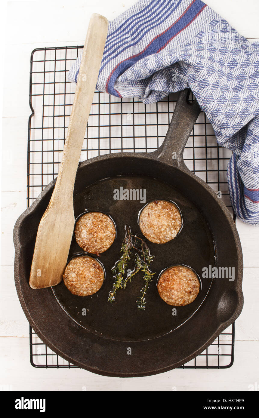 sliced irish white pudding with thyme and vegetable oil in a cast iron ...