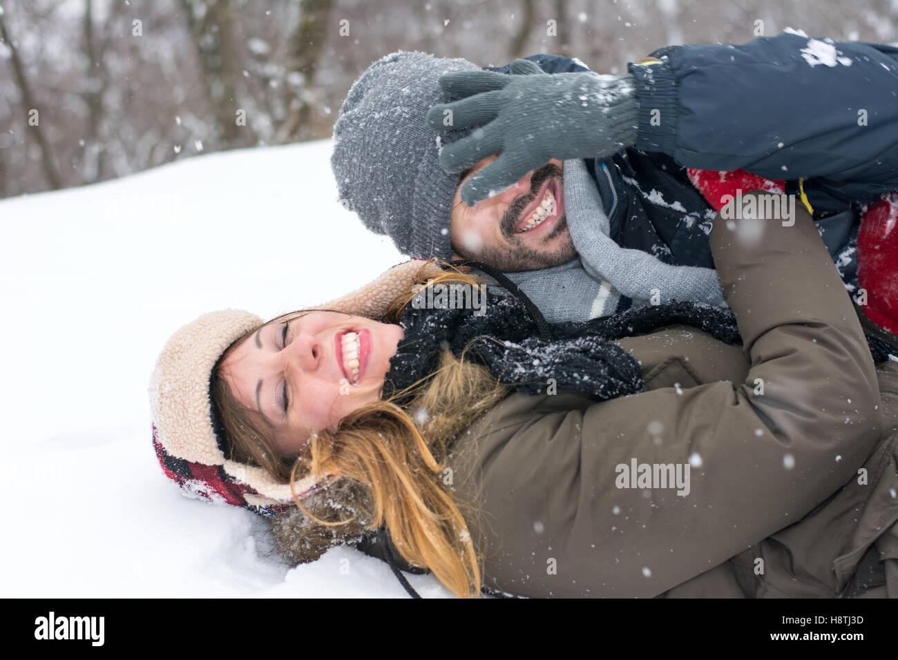 Couple having fun in a snow covered park Stock Photo - Alamy