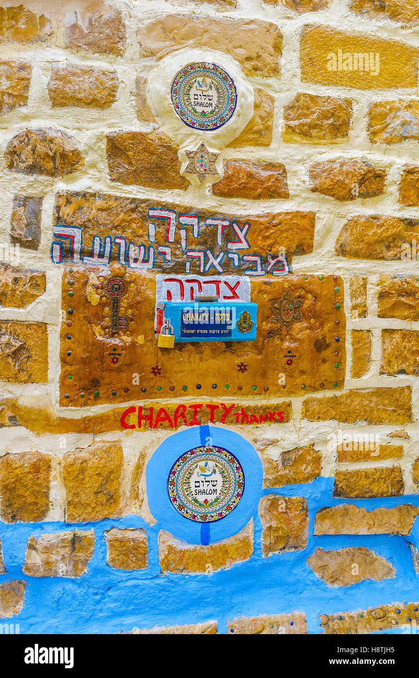 The donation box, built in the stone wall and surrounded by circle ...