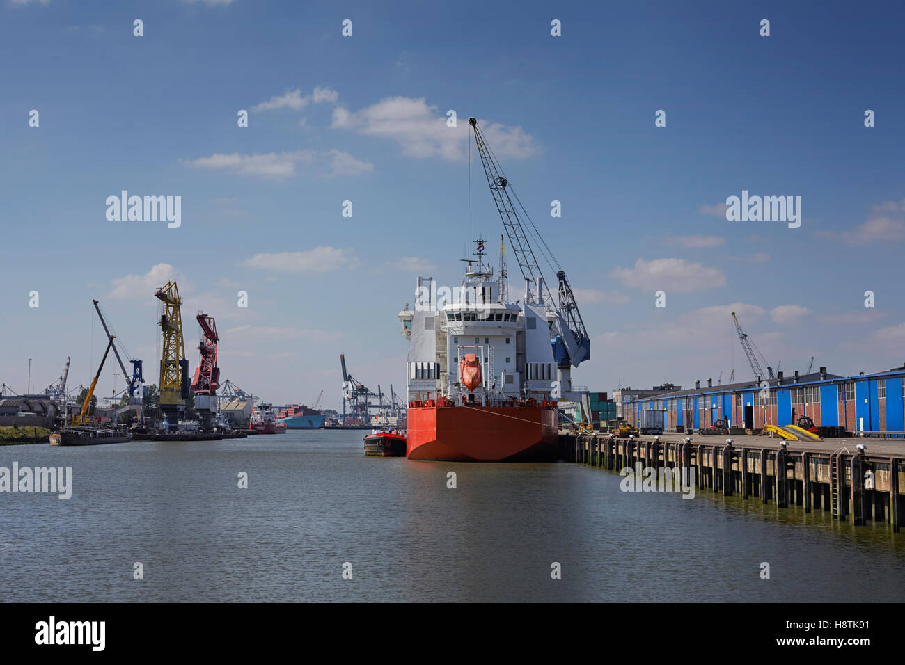 industrial ship with a life boat at a sunny day get unloaded in the ...
