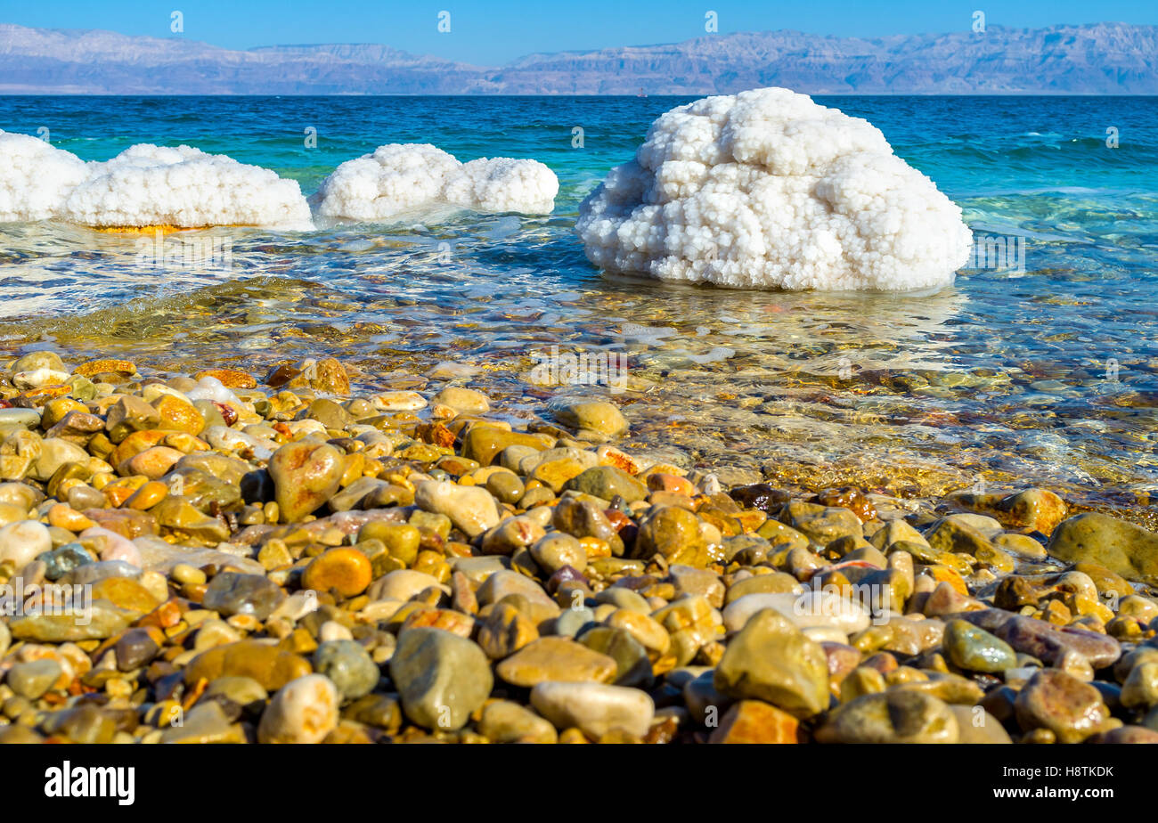 The pebble beach on the Dead Sea with the large, covered by salt ...