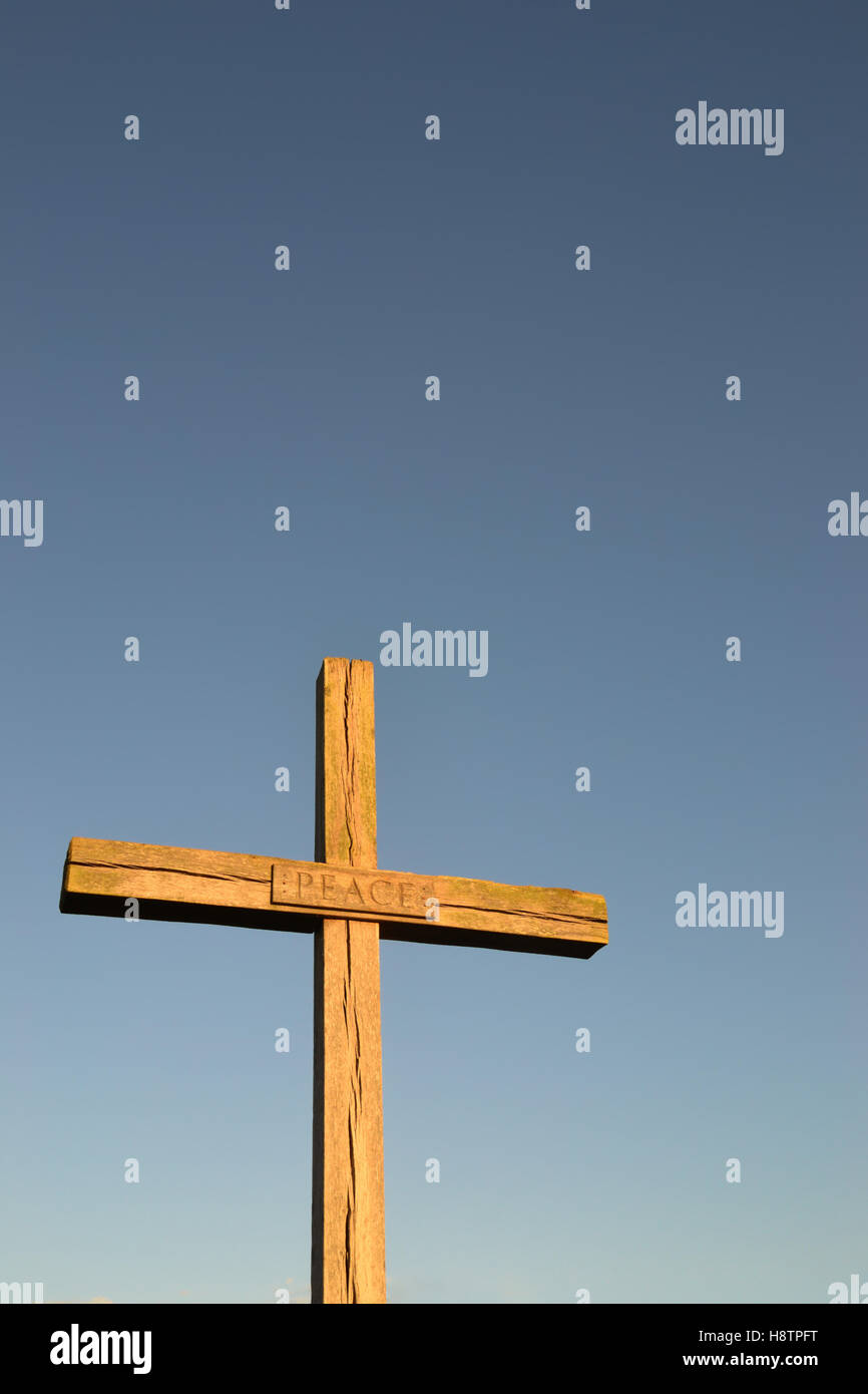 Simple wooden Christian cross with the word 'PEACE' on an attached sign ...
