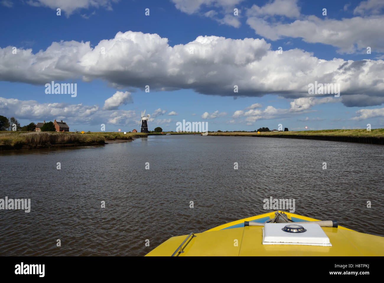 Bow of a yellow boat on the River Yare heading towards Berney Arms Mill ...