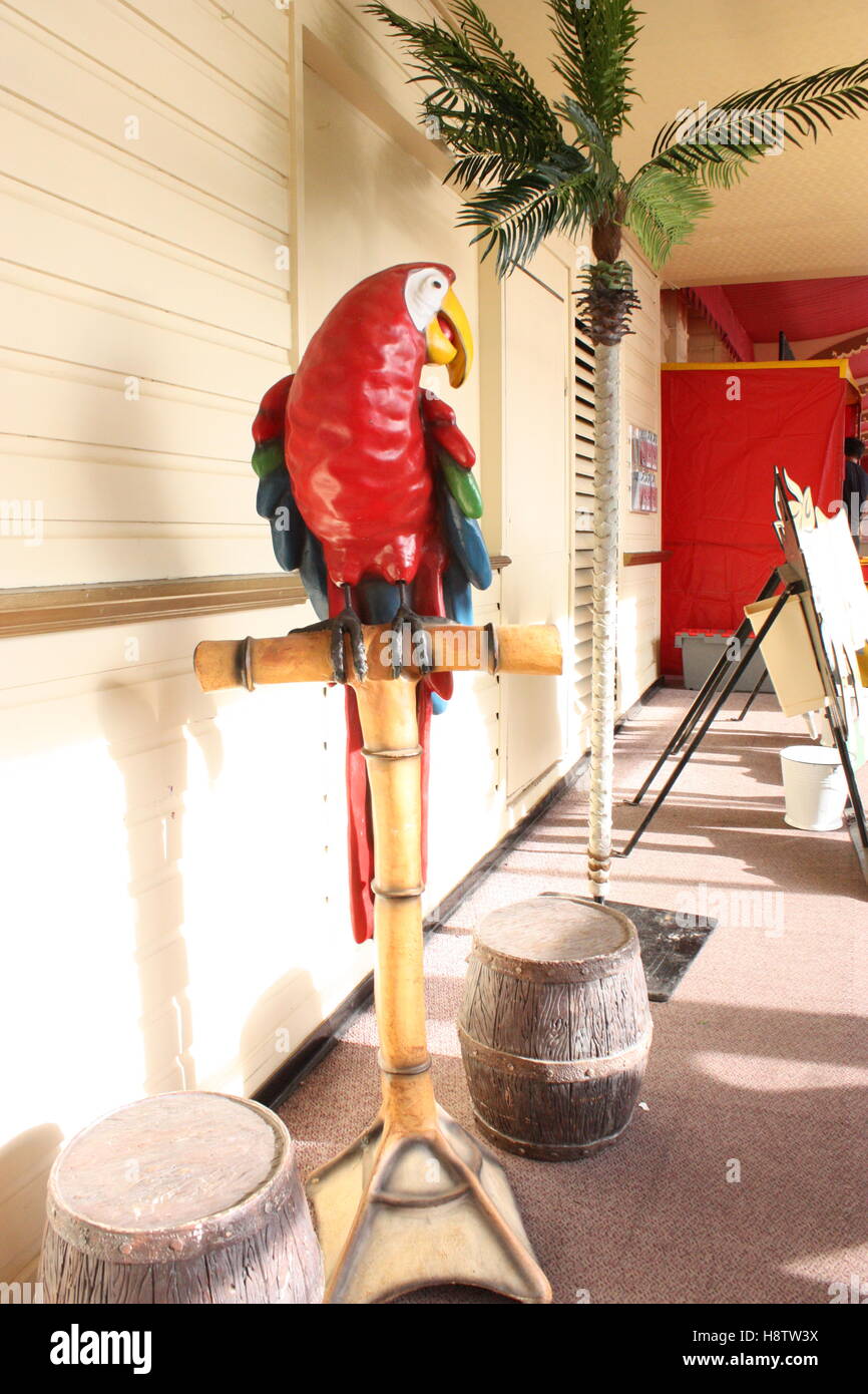 Fake parrot statue prop in a long corridor with a palm tree in the ...