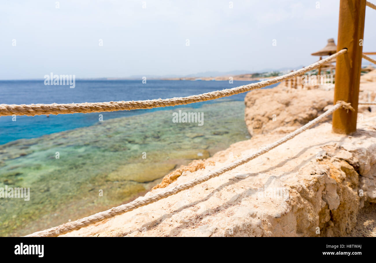 View of the sea with corals and reefs through a small wooden fence with ...