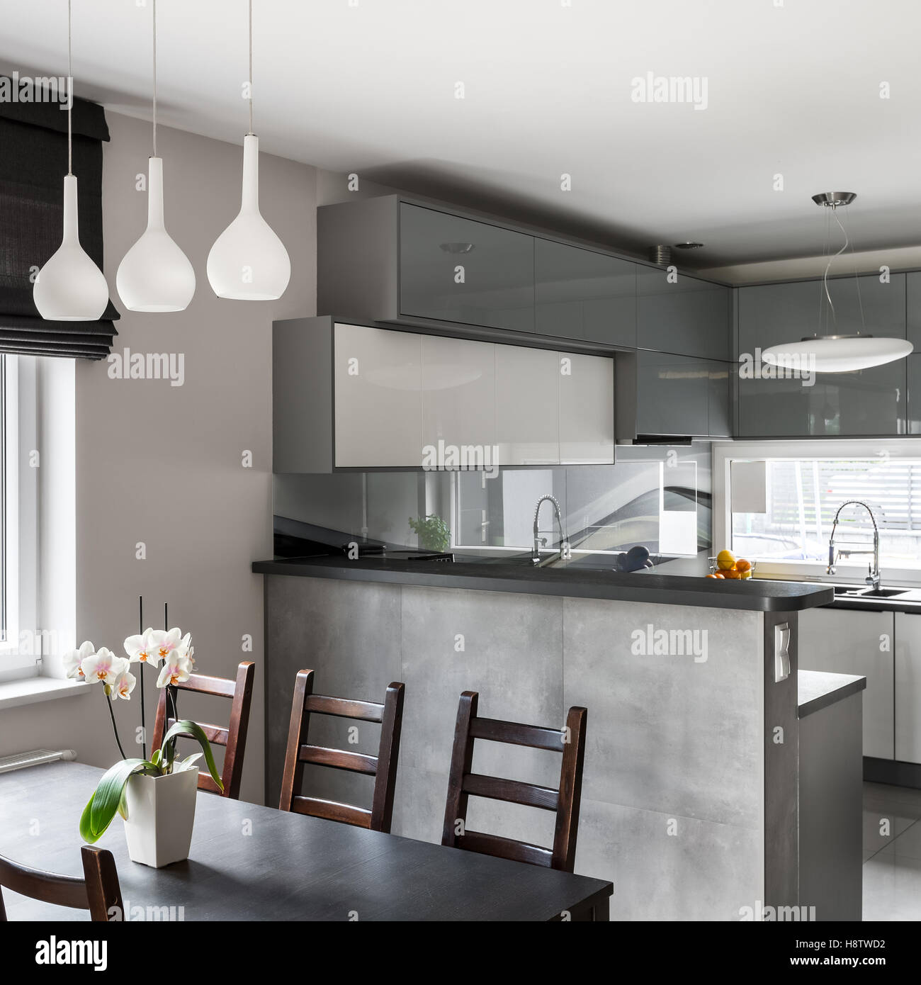 Wooden dining set and pendant lamp, bright grey open kitchen in the ...