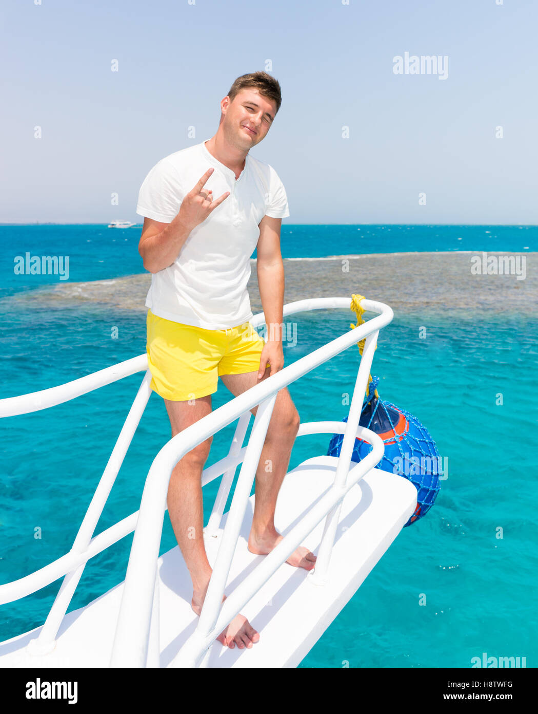 Handsome man standing on the yacht at a sunny summer day, beautiful ...