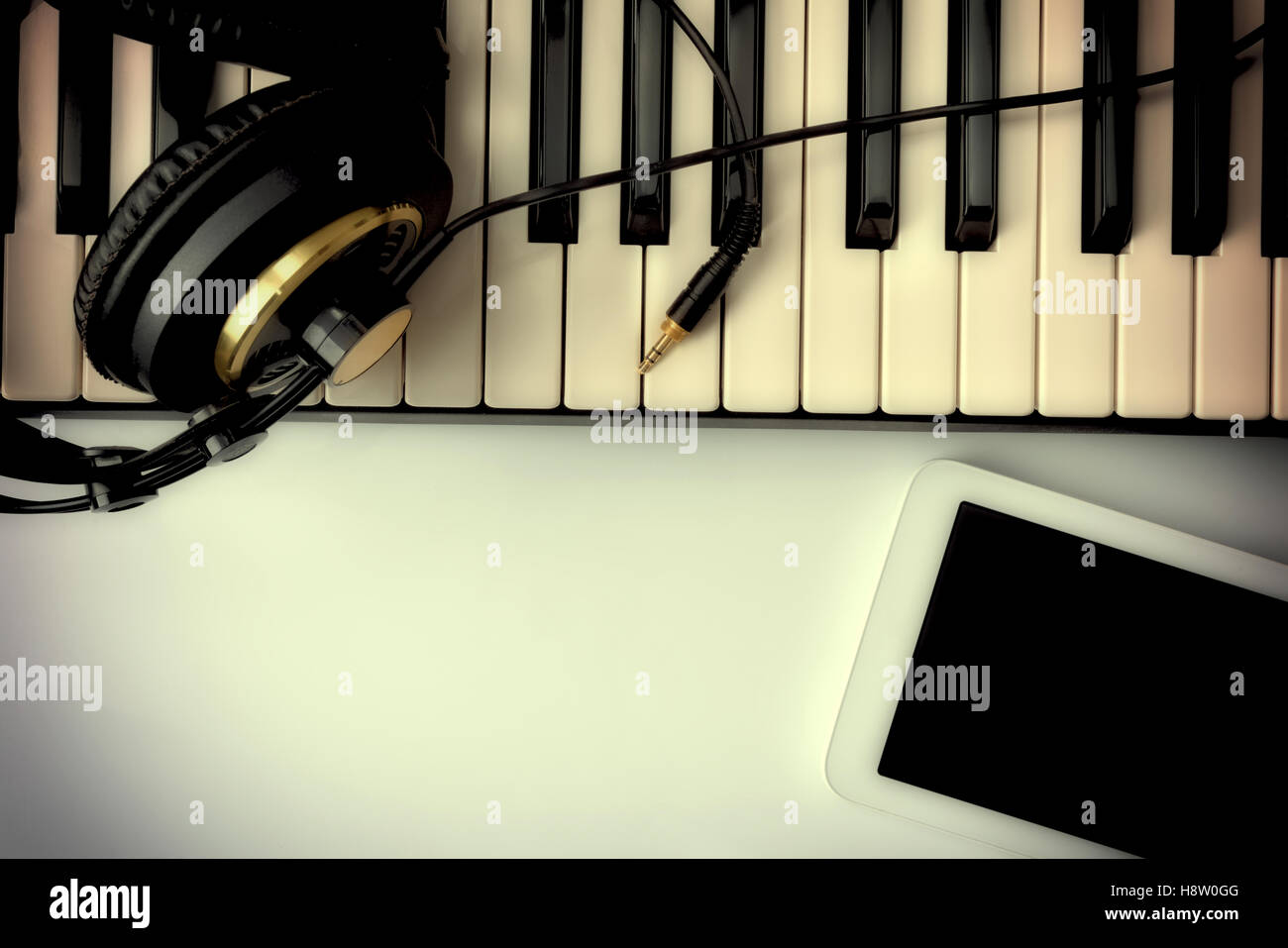 Electronic piano with headphones and tablet for musical composition ...