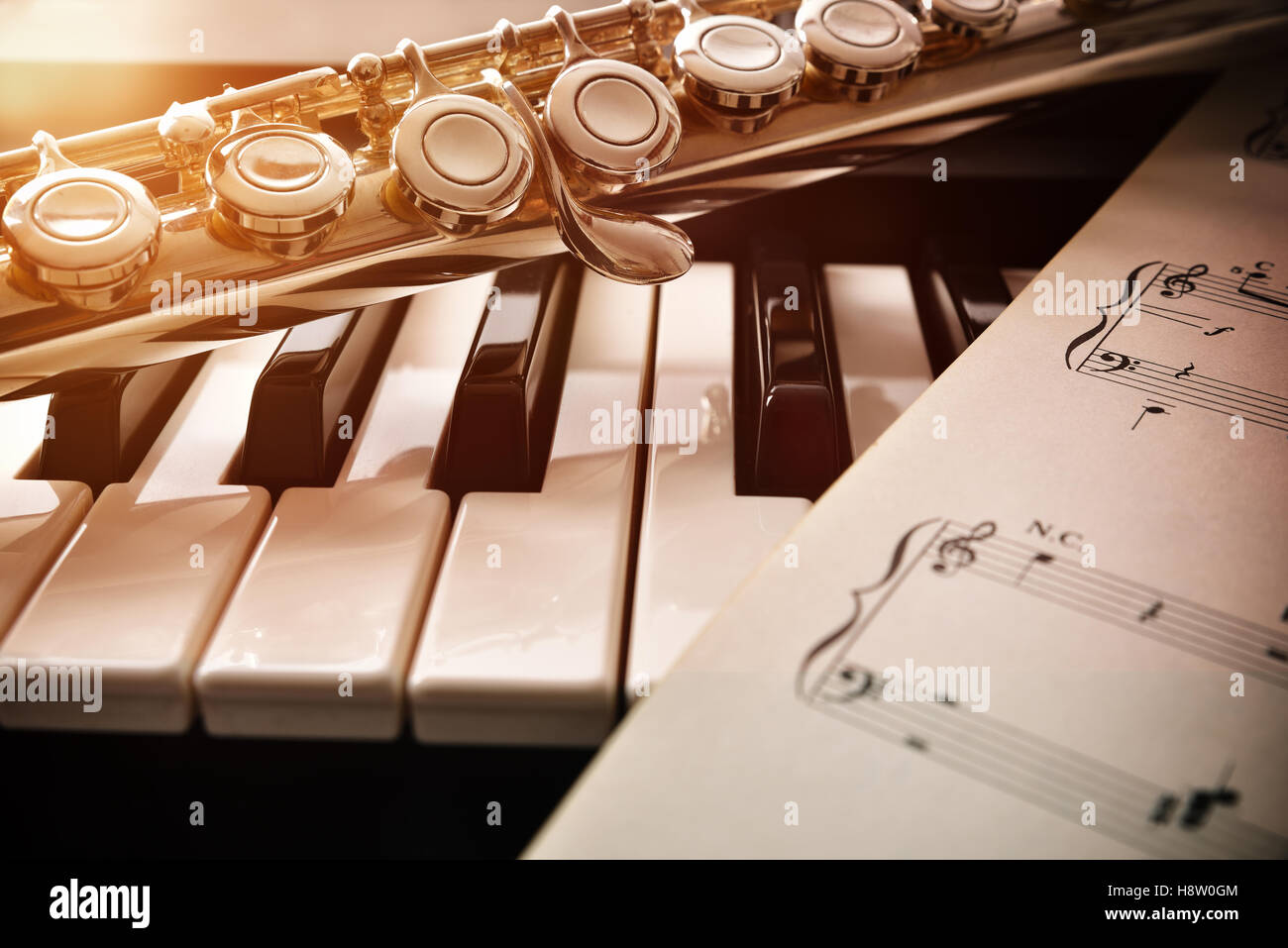 Piano and flute with golden shine and sheet music. Horizontal ...