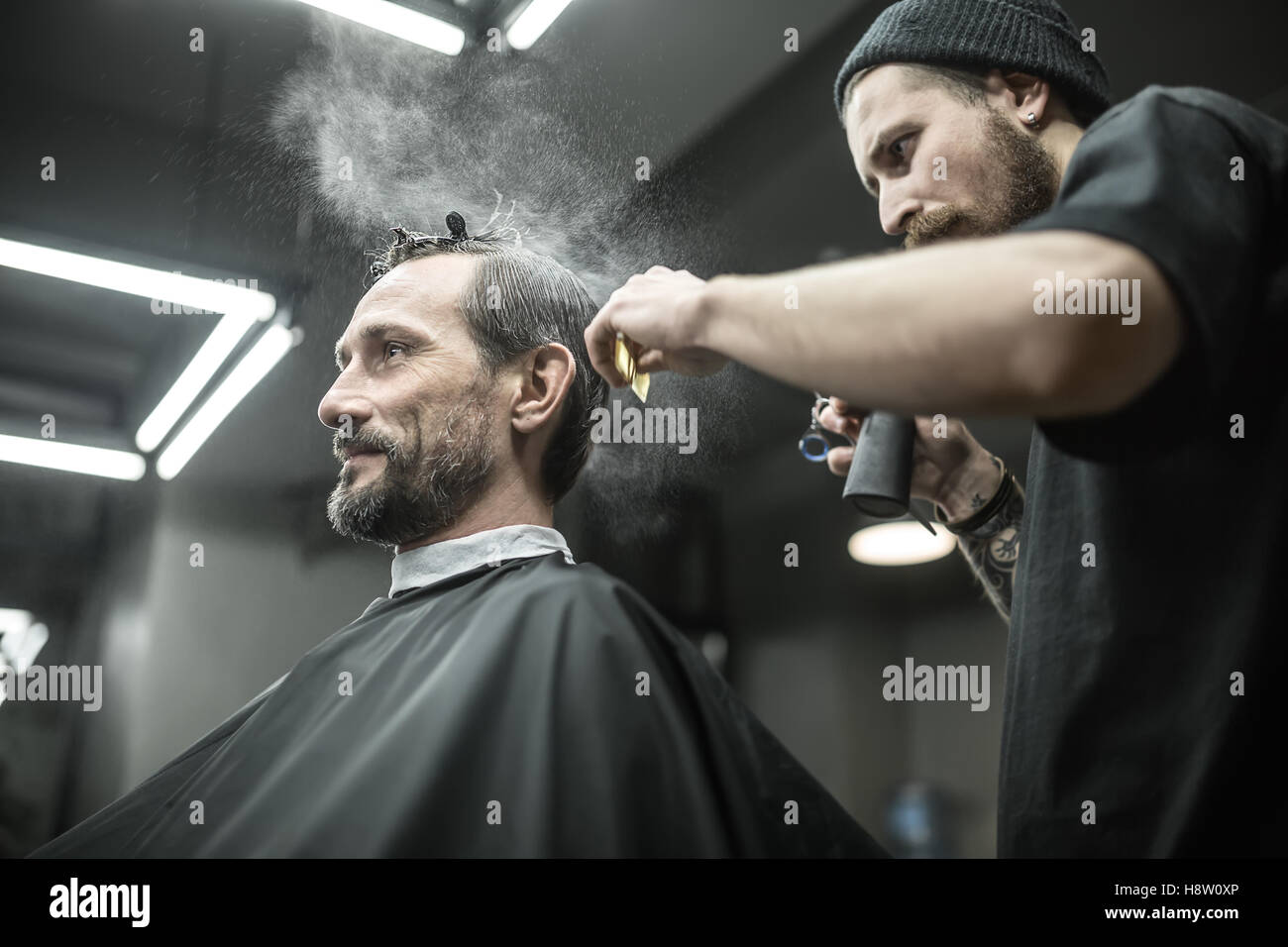 Barber is using spray bottle Stock Photo - Alamy
