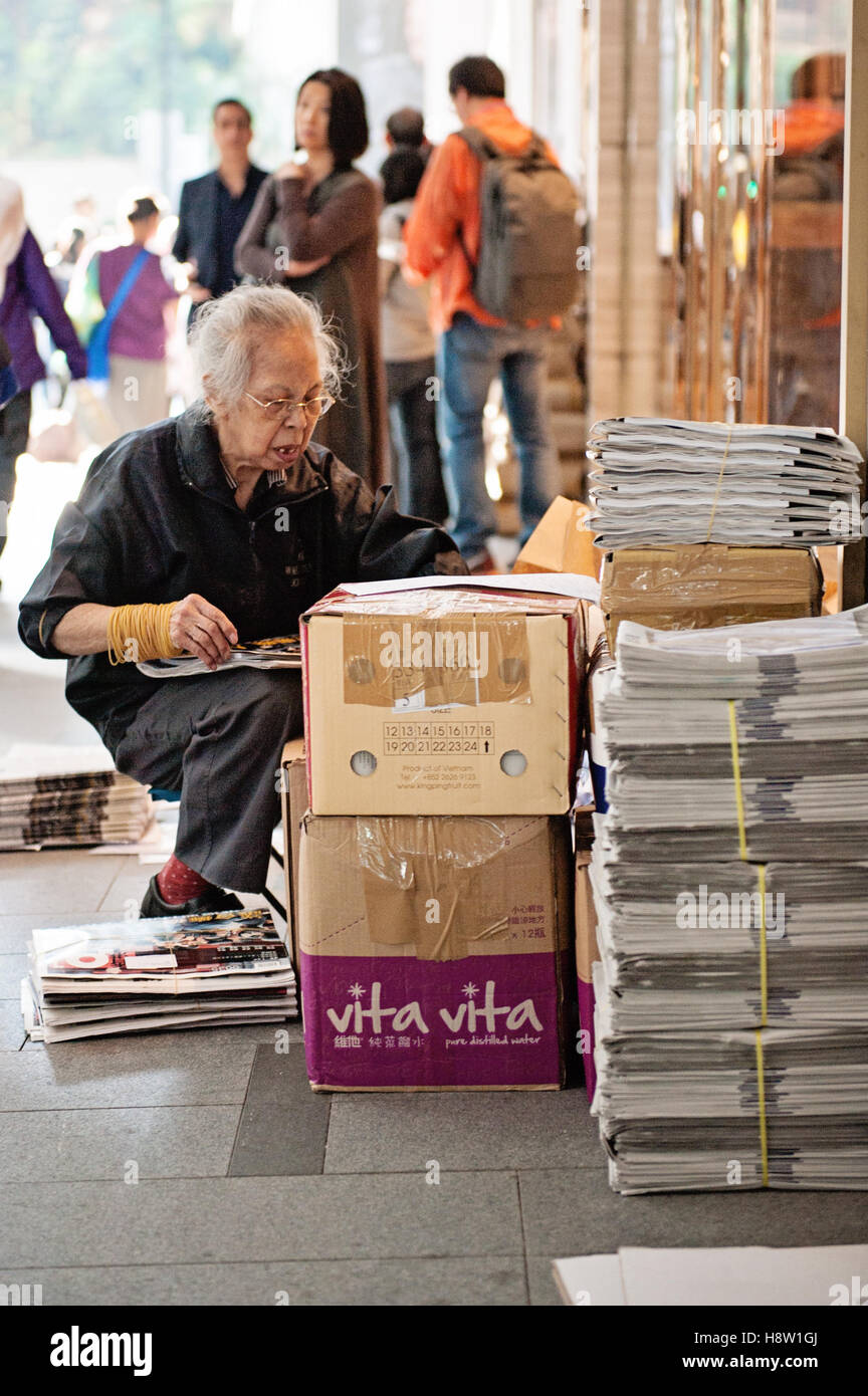 Old woman sorting and selling newspapers in Admiralty, Hong Kong Stock ...