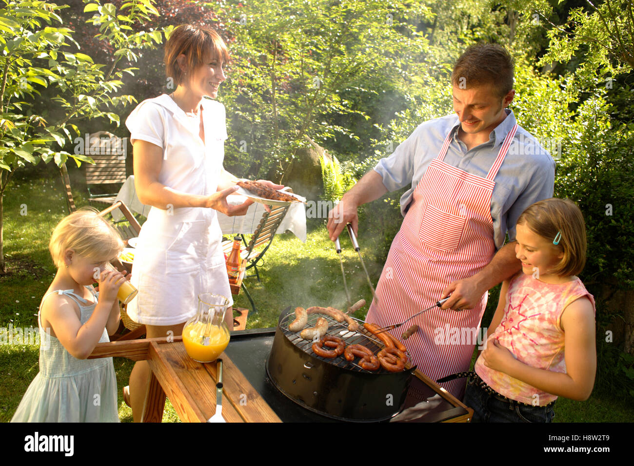 Family having a barbecue in the garden Stock Photo - Alamy