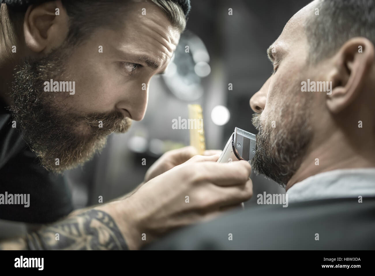 Trimming beard in barbershop Stock Photo - Alamy