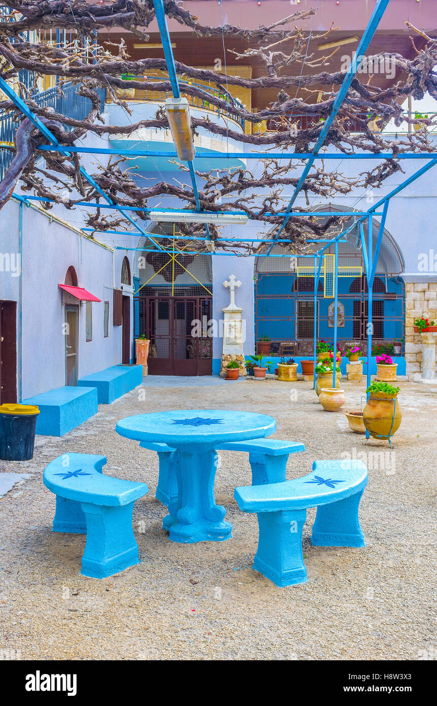 The cozy courtyard with table and benches under the grape canopy of ...