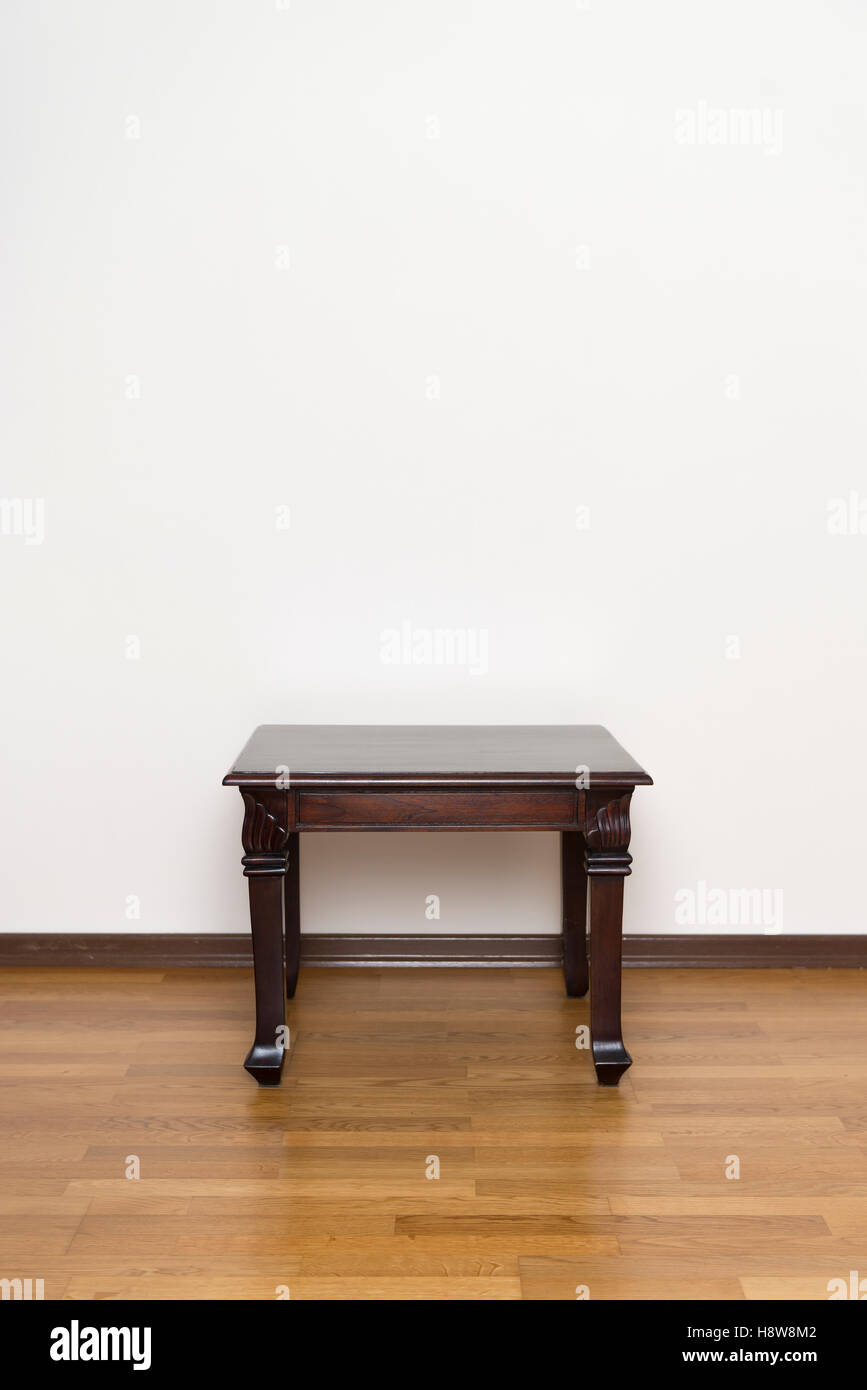 Hand made wooden side table against wall with copyspace Stock Photo - Alamy